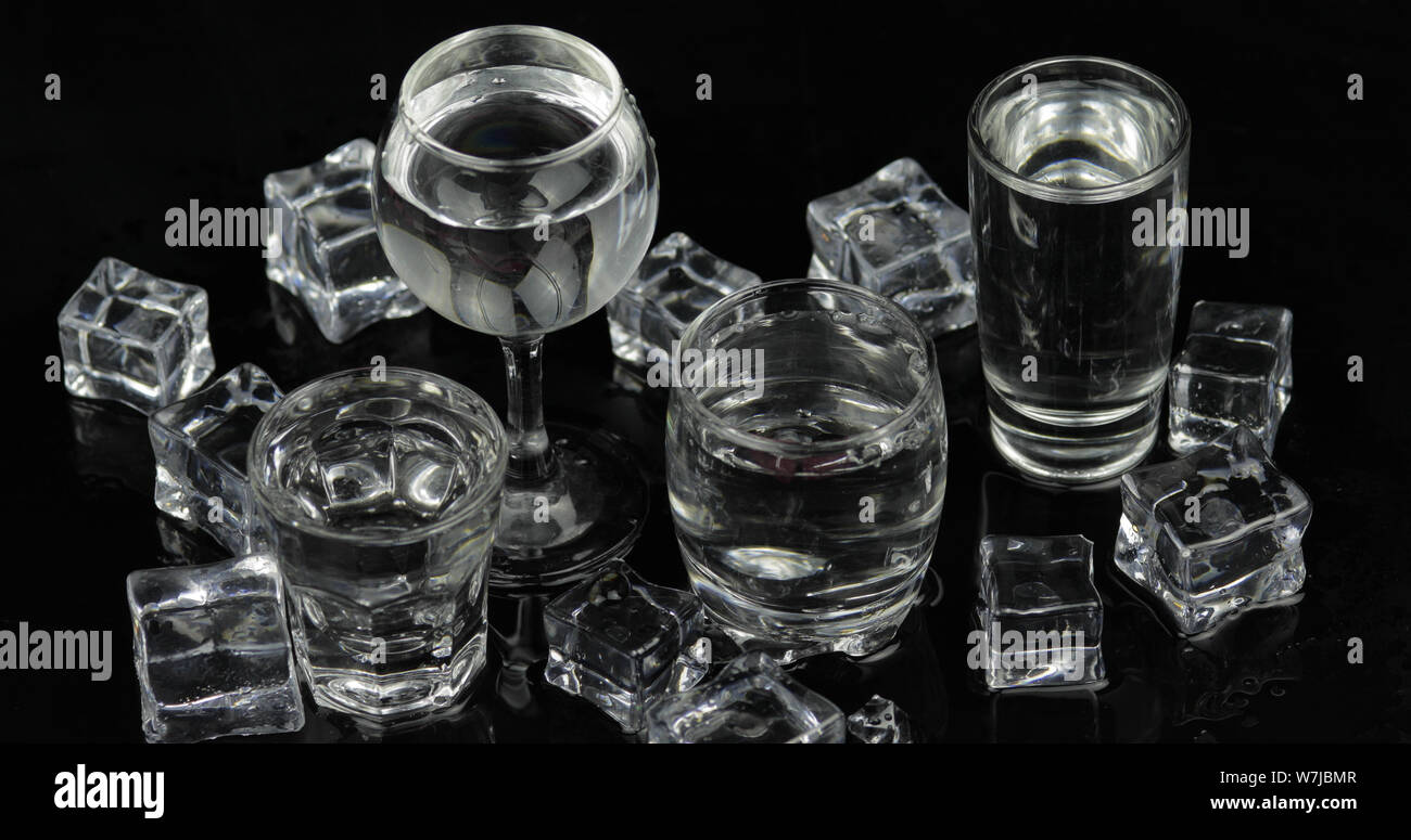 Shots of vodka with ice cubes against black background. Alcohol drink ...