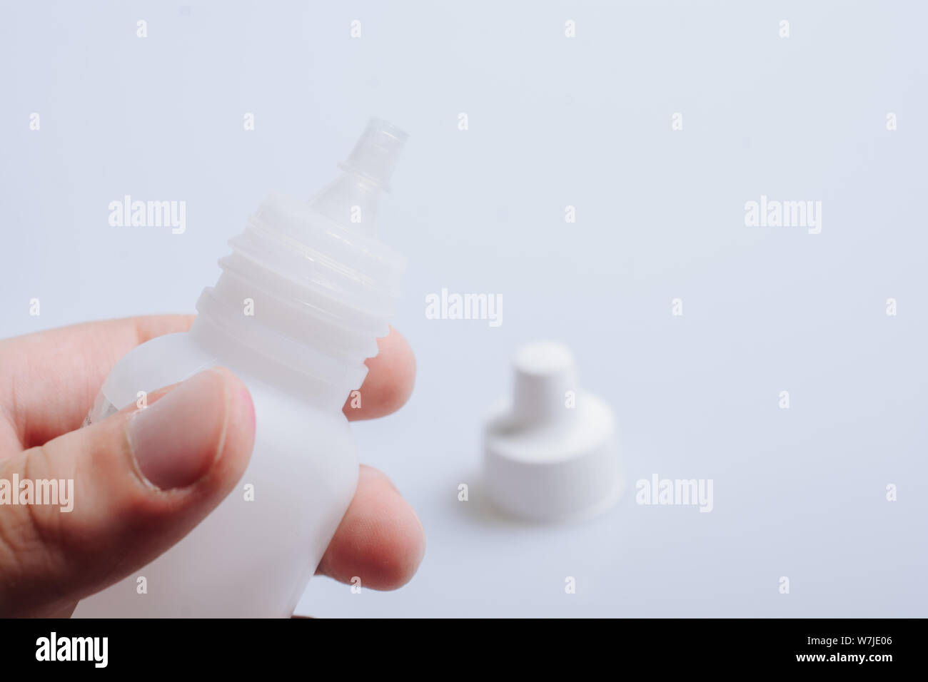White empty dropper bottle in hand on a white background Stock Photo ...