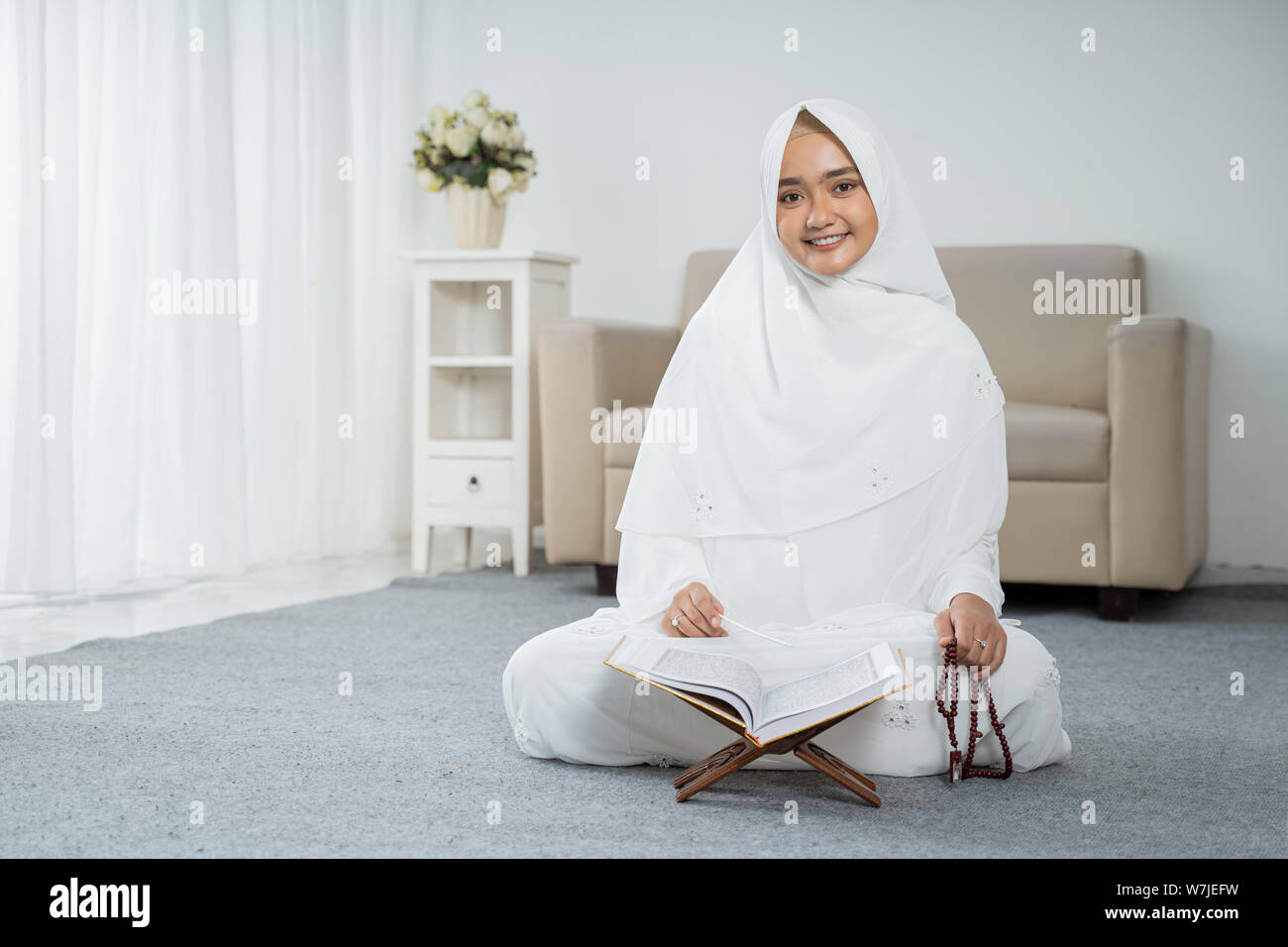 Muslim young woman praying in white traditional clothes Stock Photo - Alamy