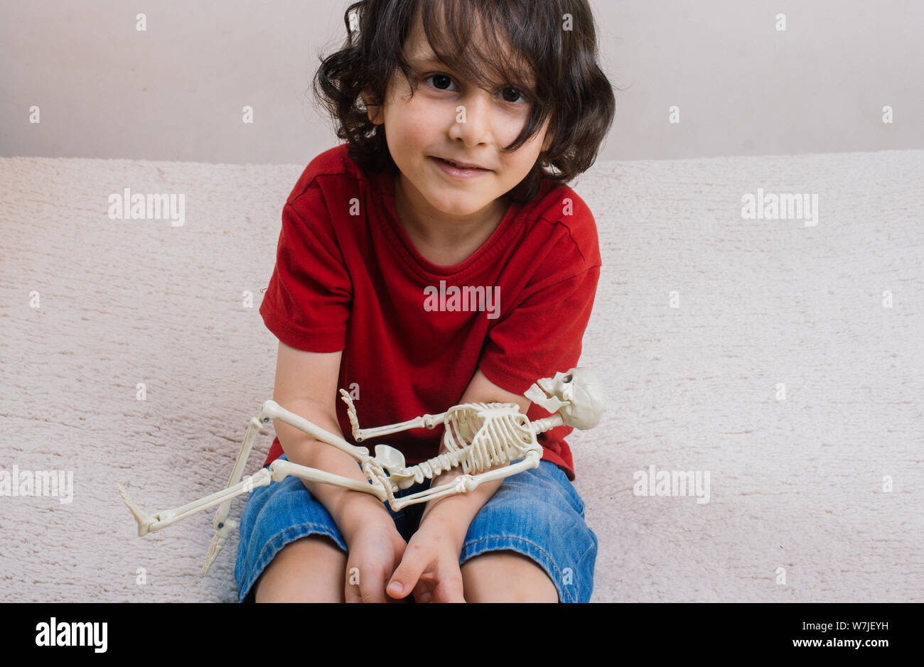 Little boy holding a small size artificial skeleton in hand Stock Photo ...