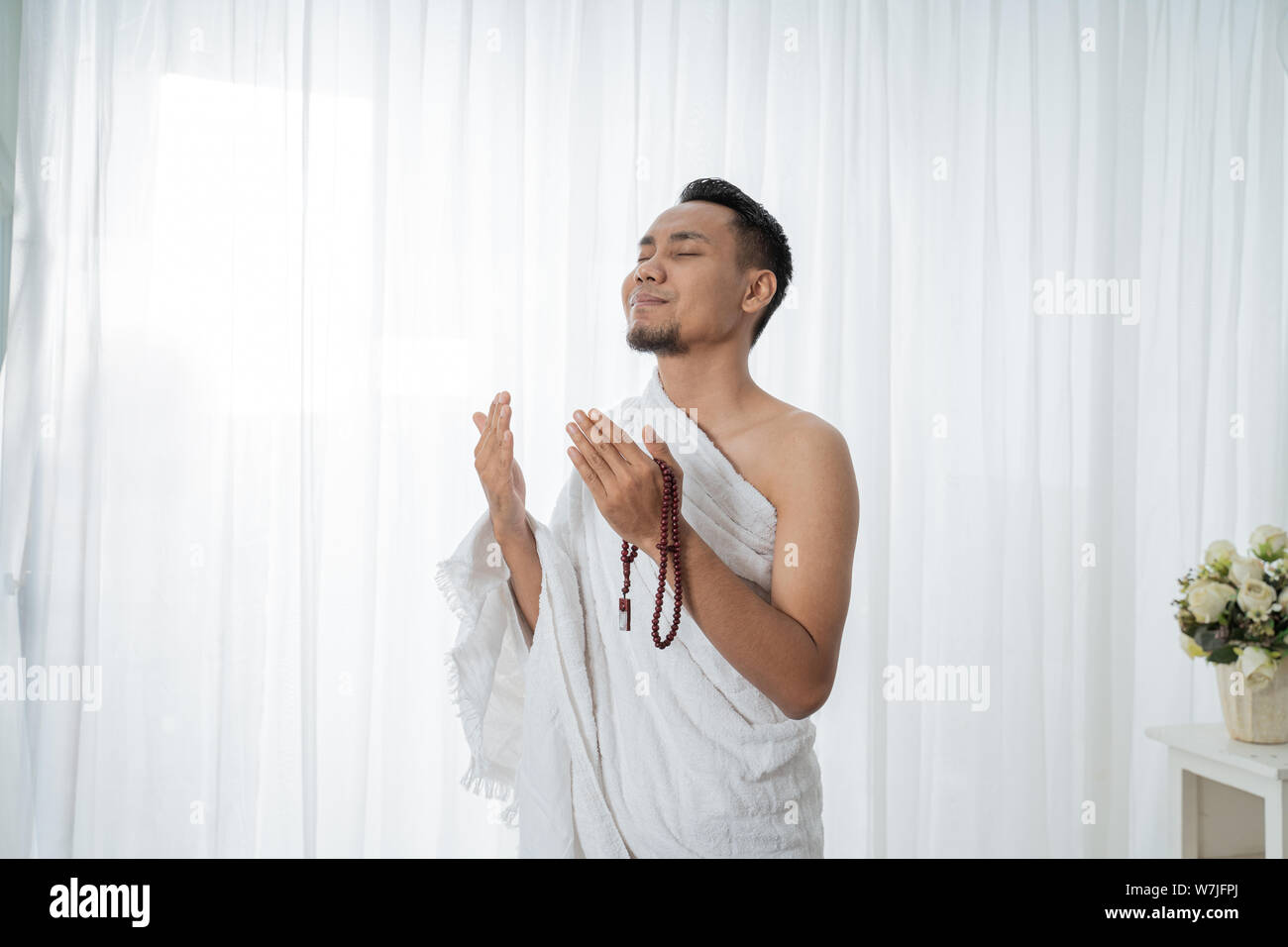 Muslim man praying in white traditional clothes Stock Photo - Alamy