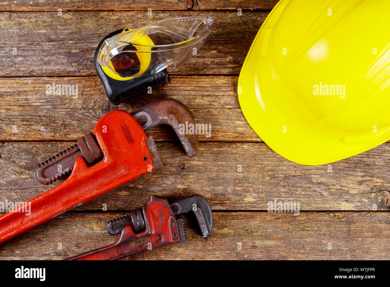 Yellow hard hat and leather work gloves and wrench construction of ...