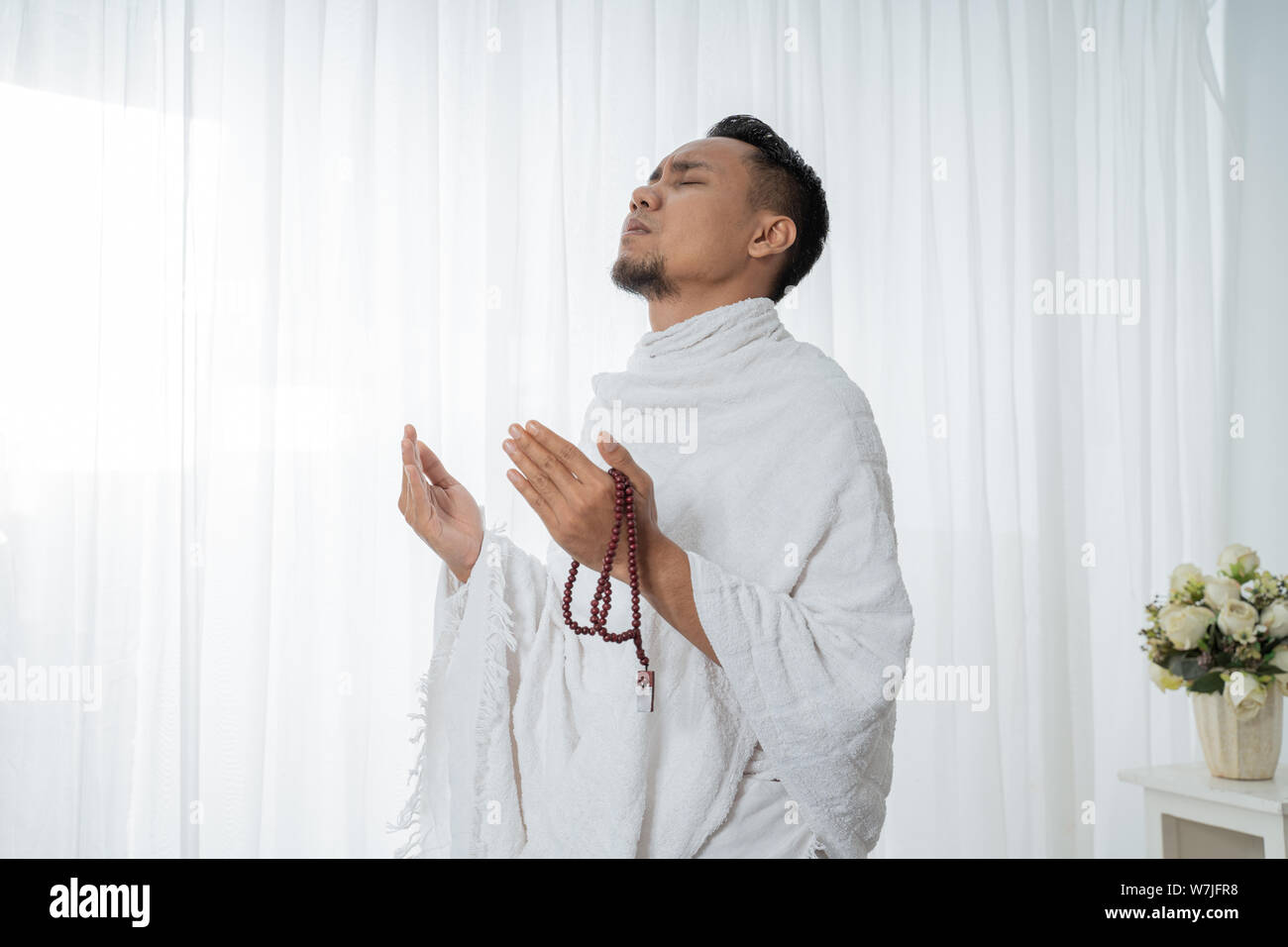 Muslim man praying in white traditional clothes Stock Photo - Alamy