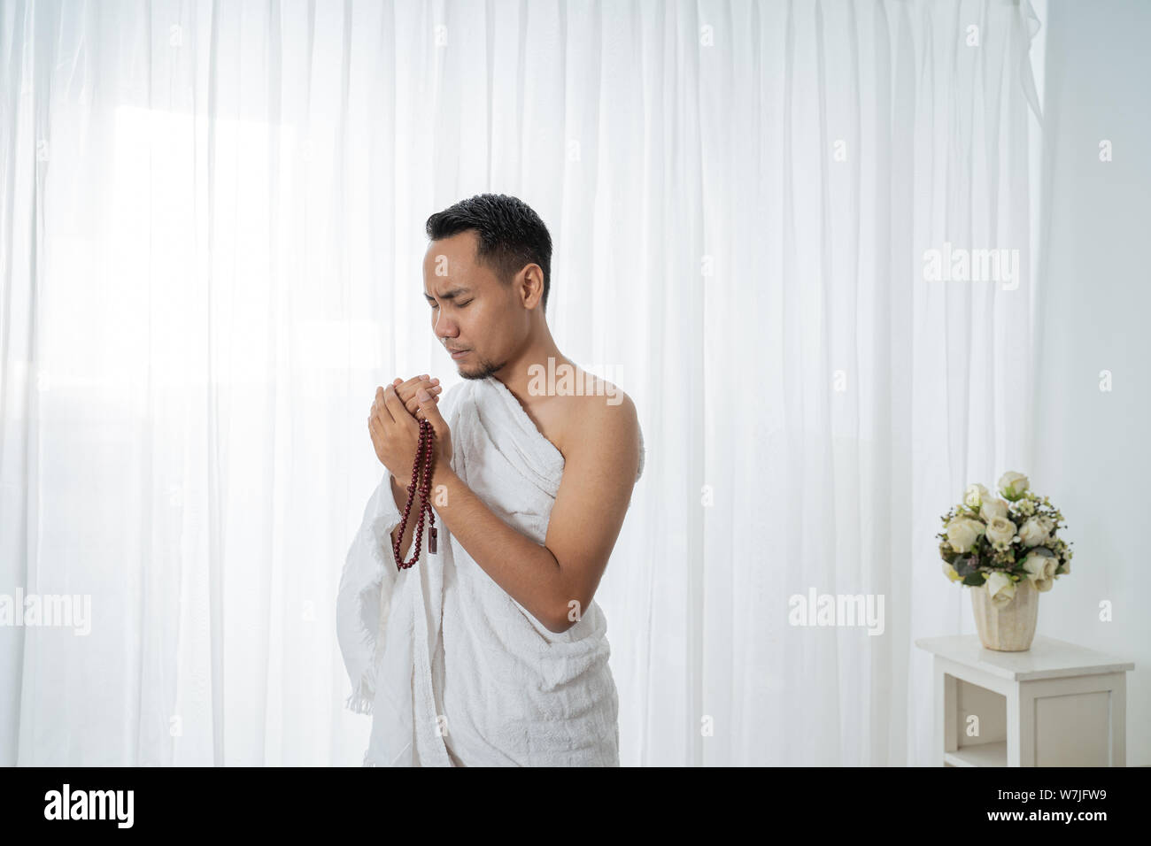 Muslim man praying in white traditional clothes Stock Photo - Alamy