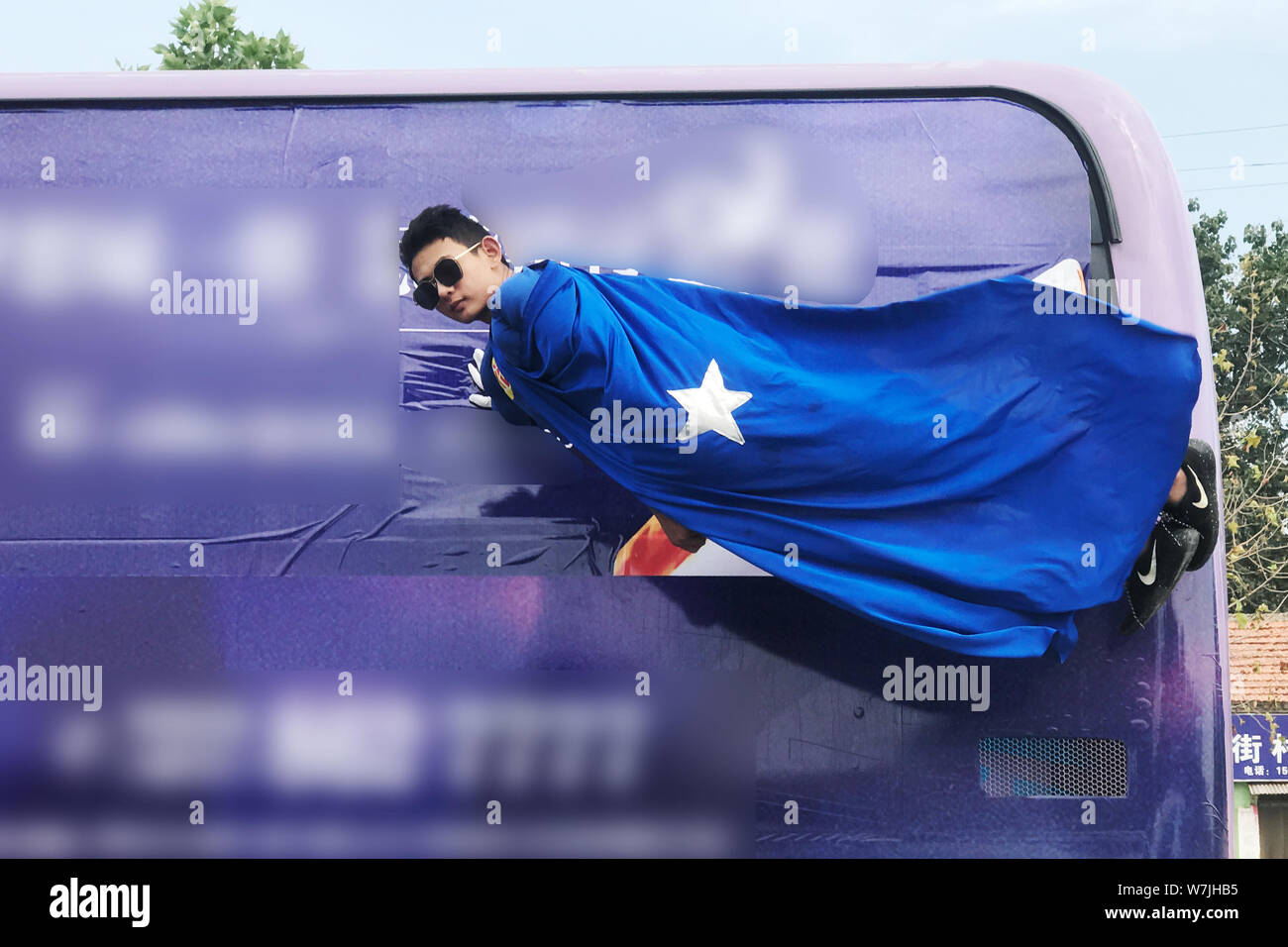 A Chinese magician dressed like Superman performing a magic show ...