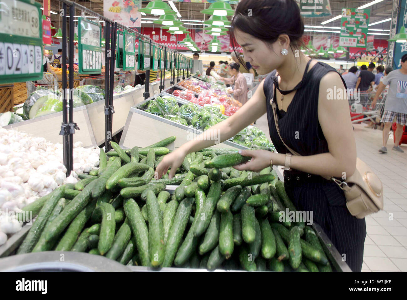 A customer shops for vegetables at a supermarket in Suzhou city, east ...
