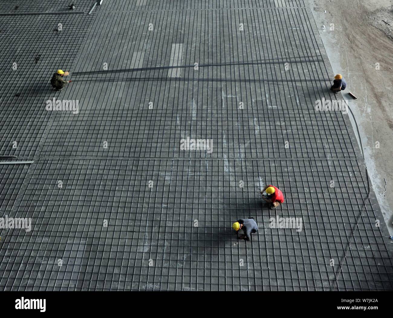 Chinese workers labor at the construction site of Chongqing West ...