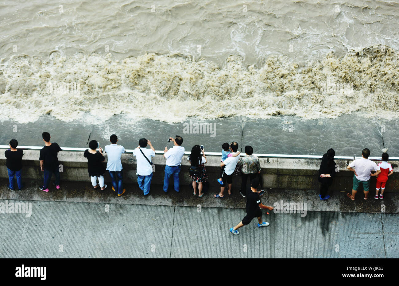 Visitors and local residents watch the tidal bore of the Qiantang River ...
