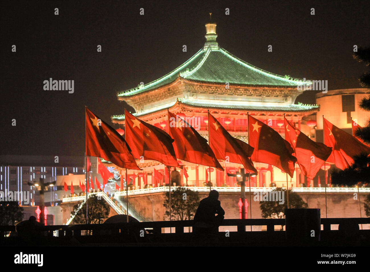 Chinese national flags flutter at night outside the Xi'an Bell Tower ...