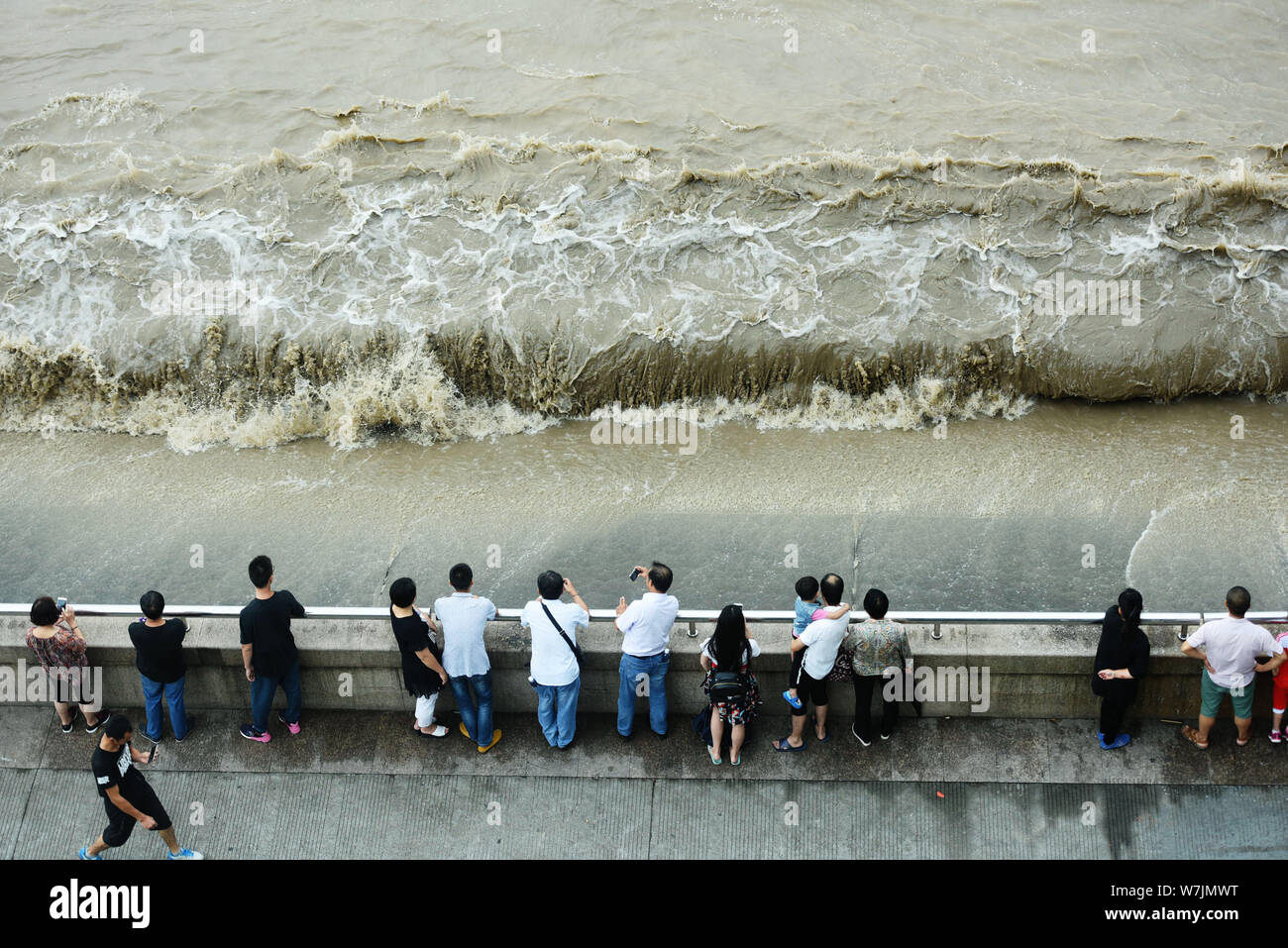 Visitors and local residents watch the tidal bore of the Qiantang River ...