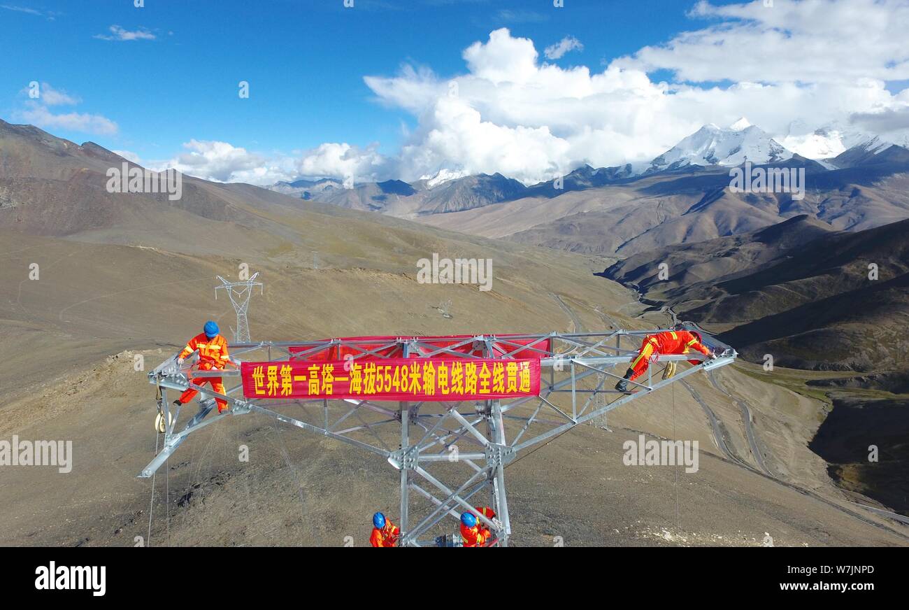 Electricity workers labour on the world's highest power transmission tower with a height of ...