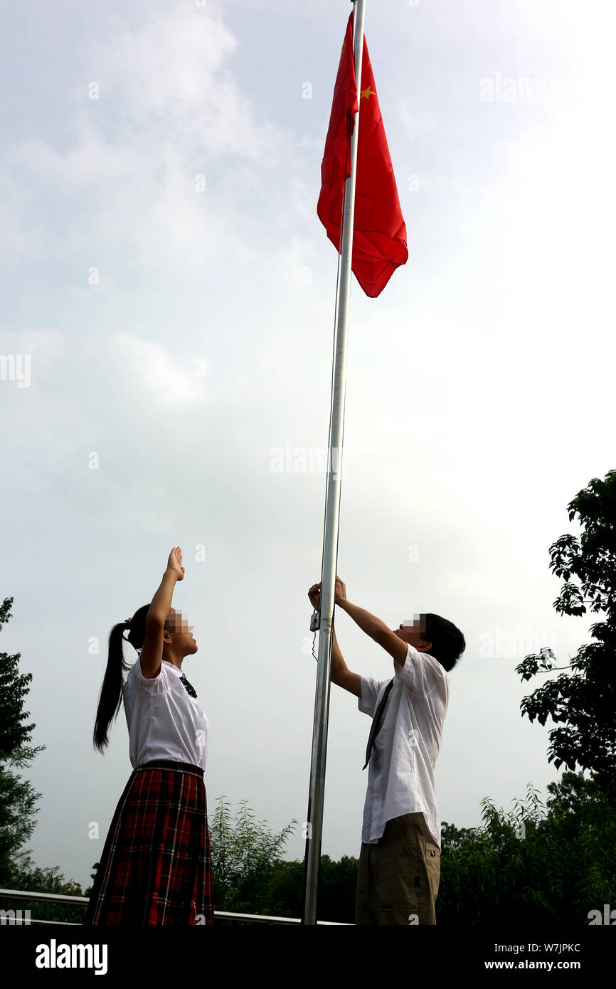 Chinese students are pictured during the ceremony of raising the ...