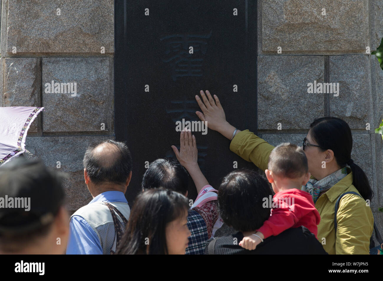 Tourists stroke a sculpture of Huo Qubing, a distinguished military ...