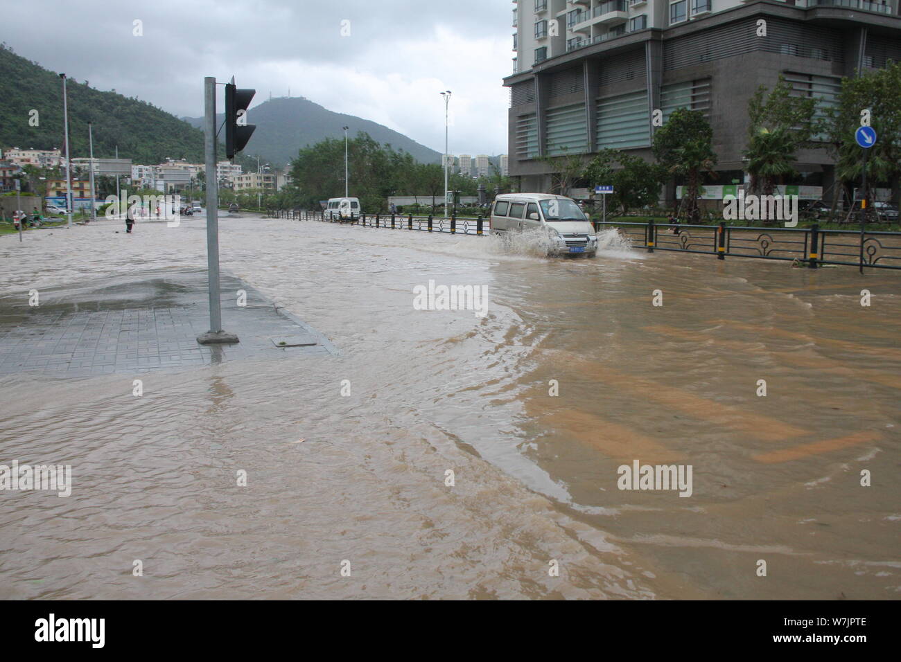 A car drives on a flooded road after heavy rain caused by Typhoon ...