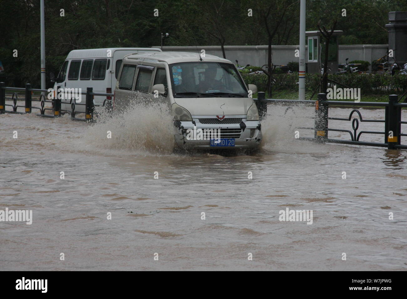 A car drives on a flooded road after heavy rain caused by Typhoon ...