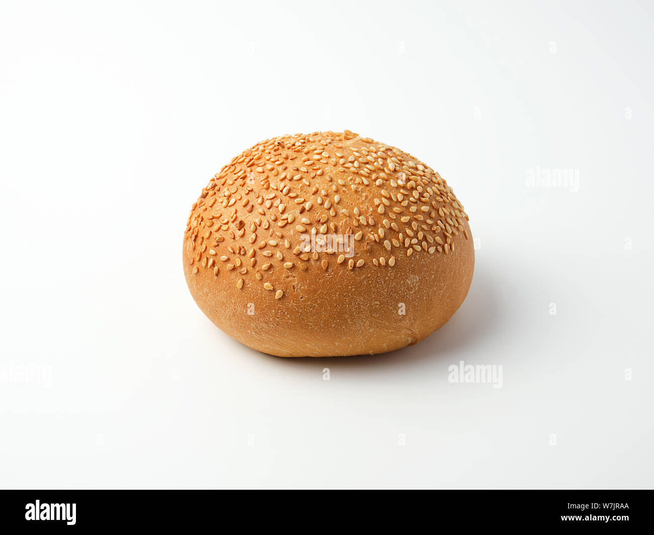 baked whole round bun with sesame seeds made from white wheat flour on ...