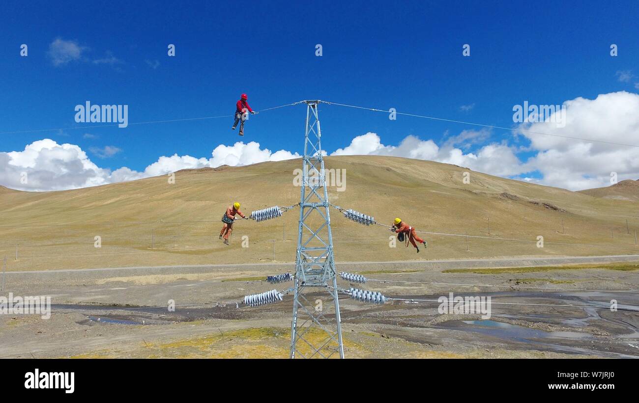 Chinese workers labor at the world's highest power transmission tower ...