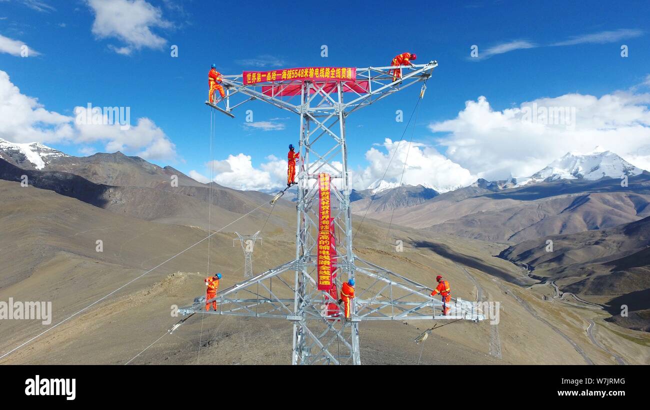 Electricity workers labour on the world's highest power transmission tower with a height of ...