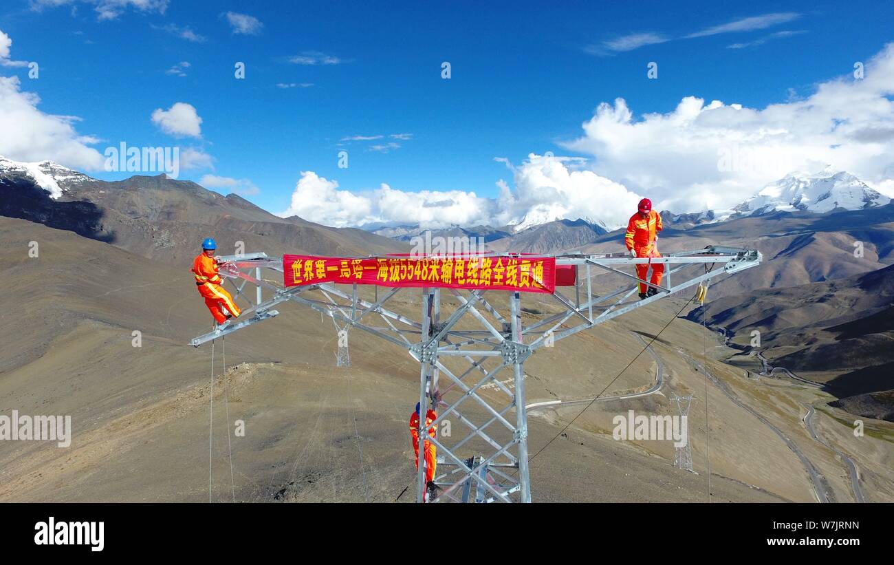 Electricity workers labour on the world's highest power transmission tower with a height of ...
