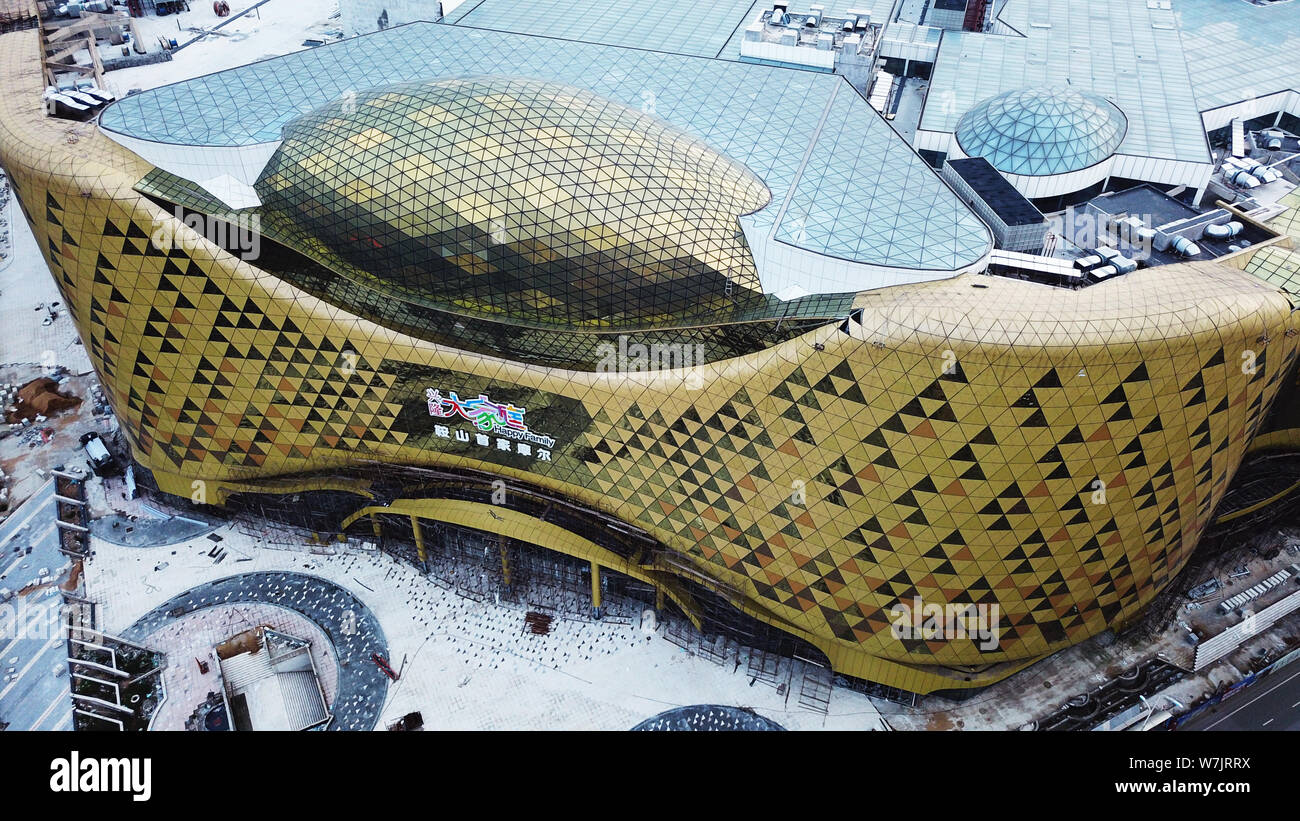 Aerial view of a shopping mall featuring the shape of a gold ingot in ...