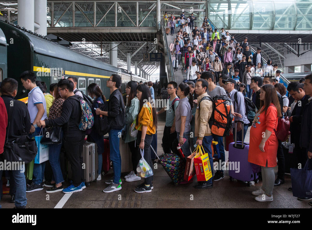 Chinese passengers queue up to board their train at the Nanjing West ...