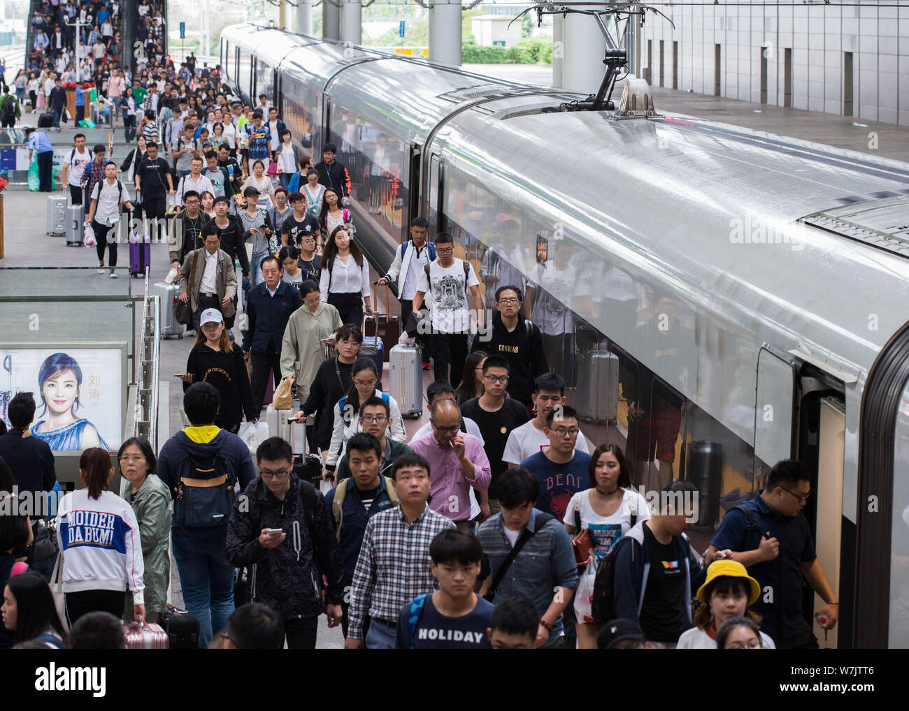 Crowds of Chinese passengers walk on the platform to board their trains ...