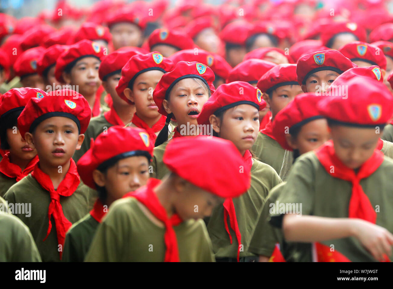A young student yawns as he and other students attend a flag-raising ...