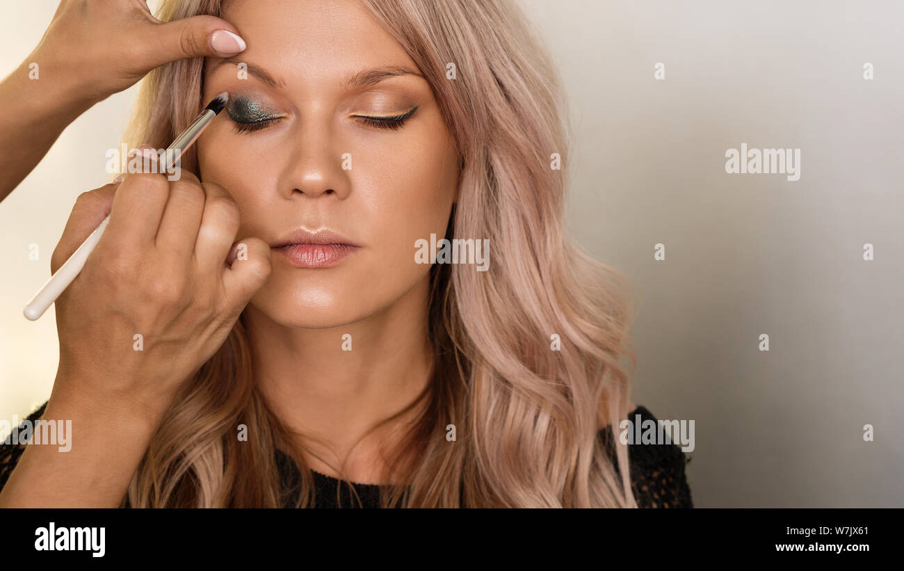 Work makeup artist. Makeup apply eyeshadow on the mobile eyelid model ...