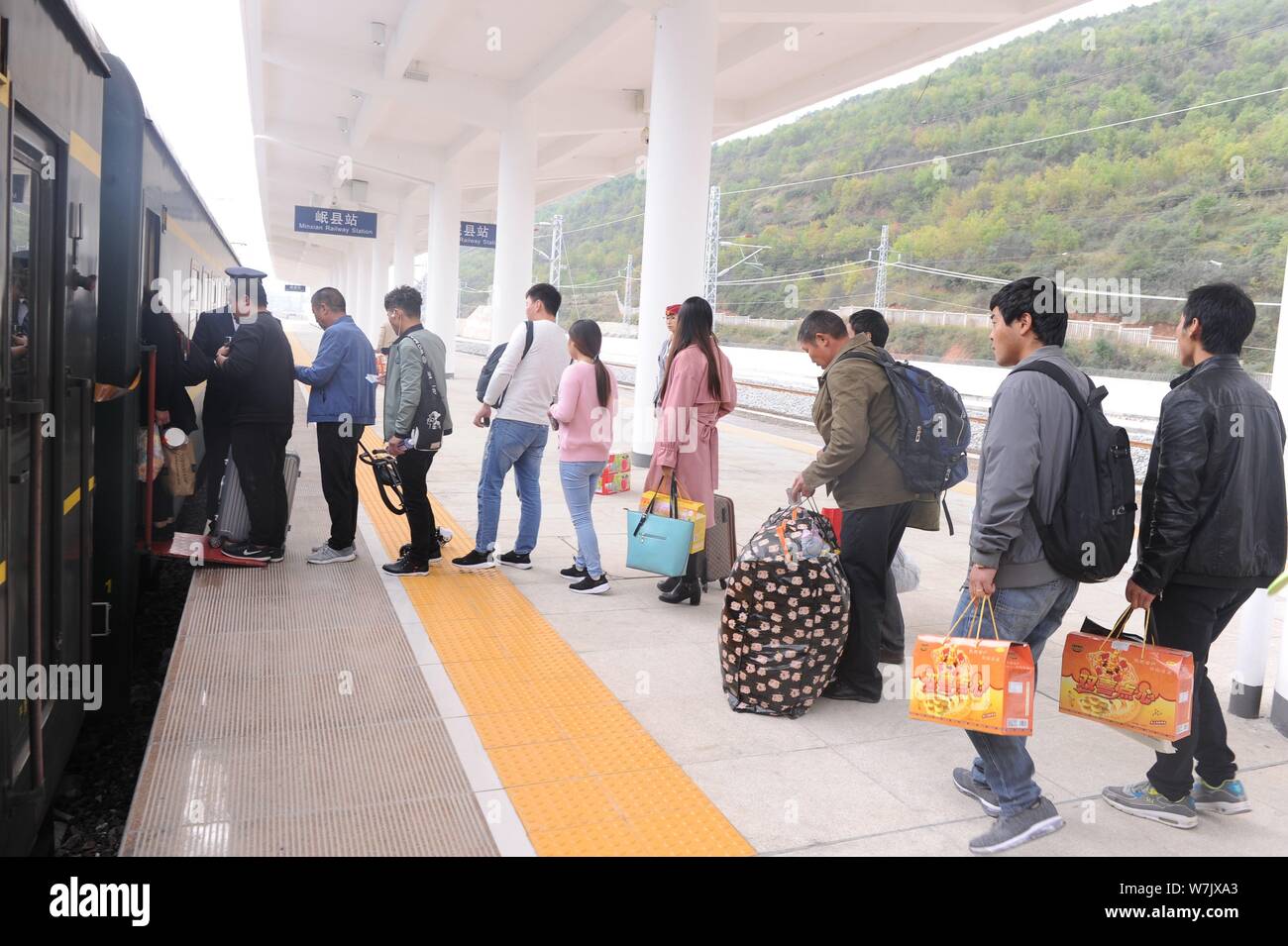 Chinese passengers queue up to board a train on the Lanzhou-Chongqing ...