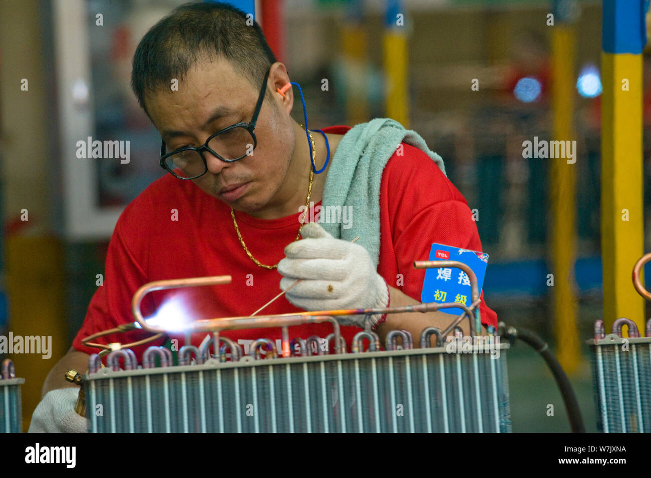 --FILE--A Chinese worker welds parts for air-conditioners on the ...