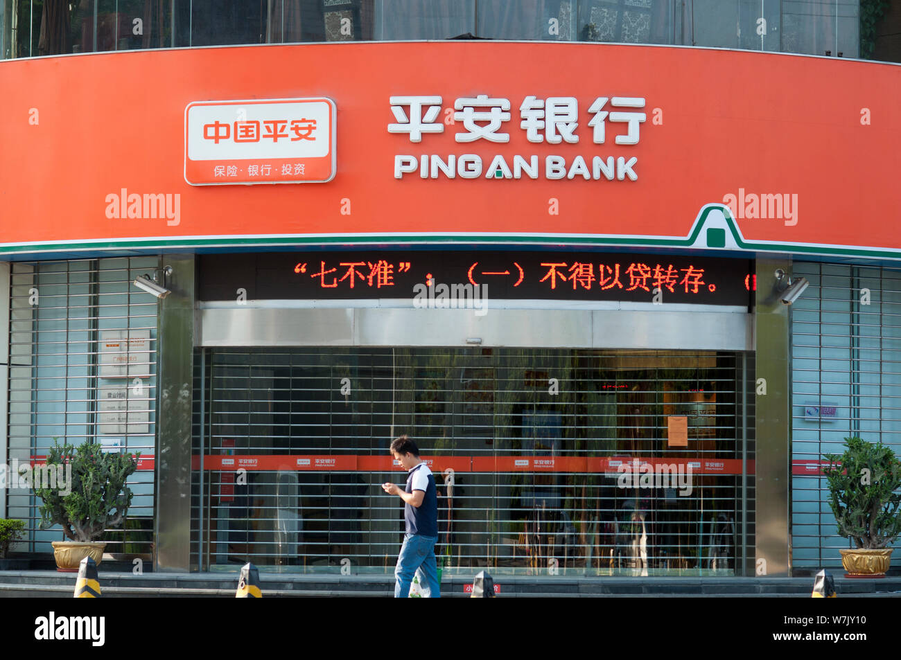 --FILE--A pedestrian walks past a branch of Ping An Bank, a subsidiary ...
