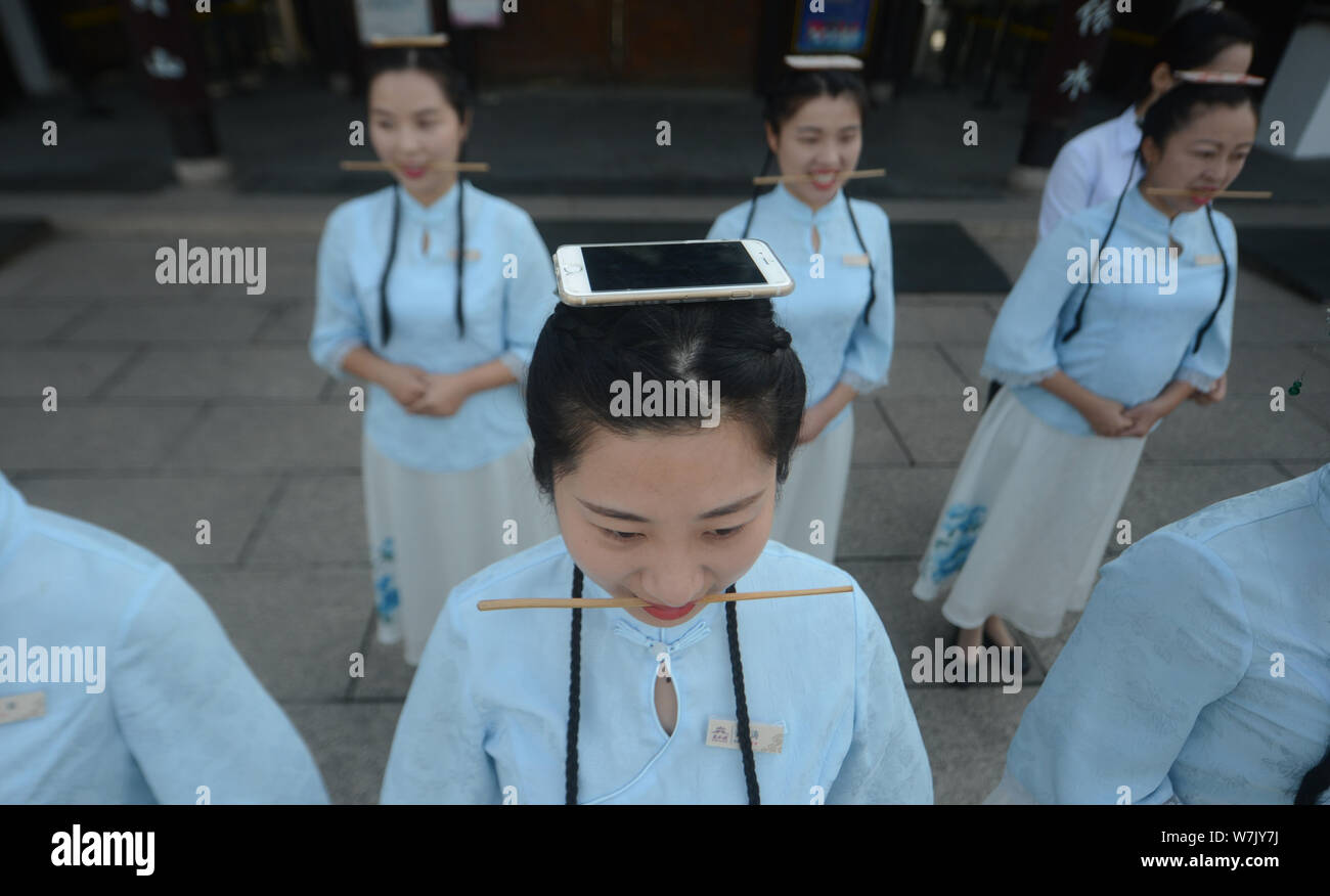 Female Chinese tour guides of Slender West Lake bite chopsticks and put ...