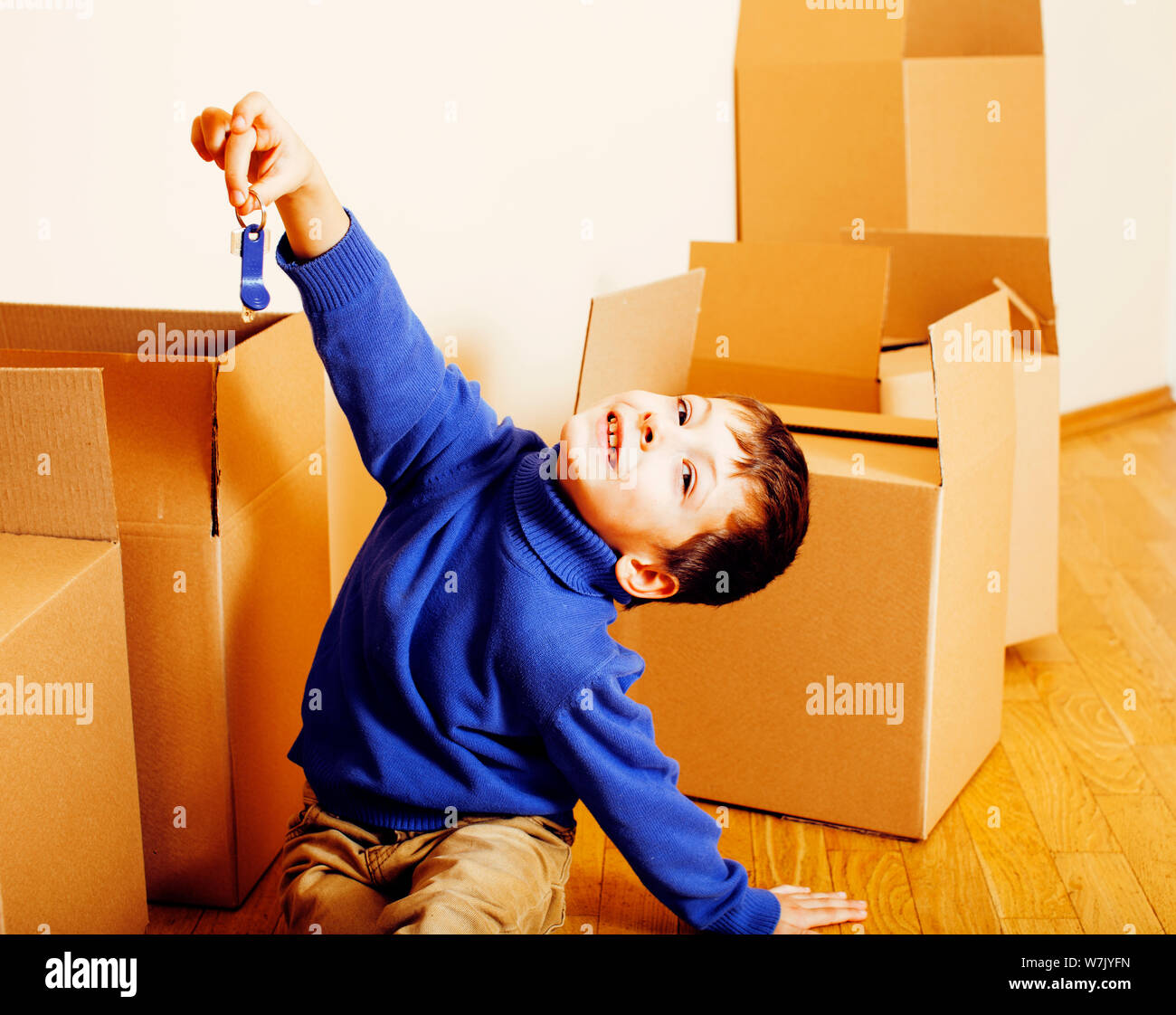little cute boy in empty room with many boxes, remoove to new home ...