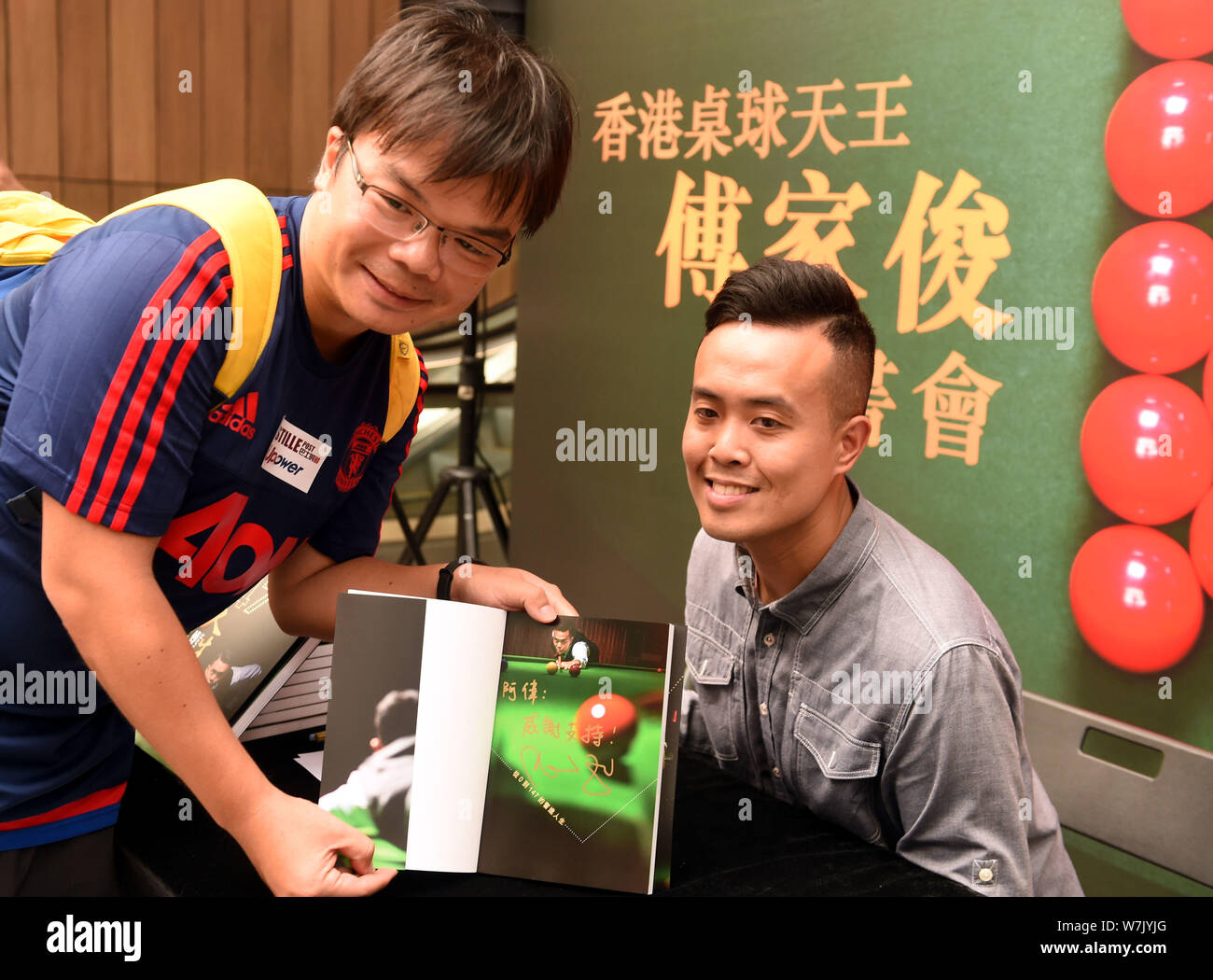 Hong Kong snooker player Marco Fu, right, poses with a fan during a ...