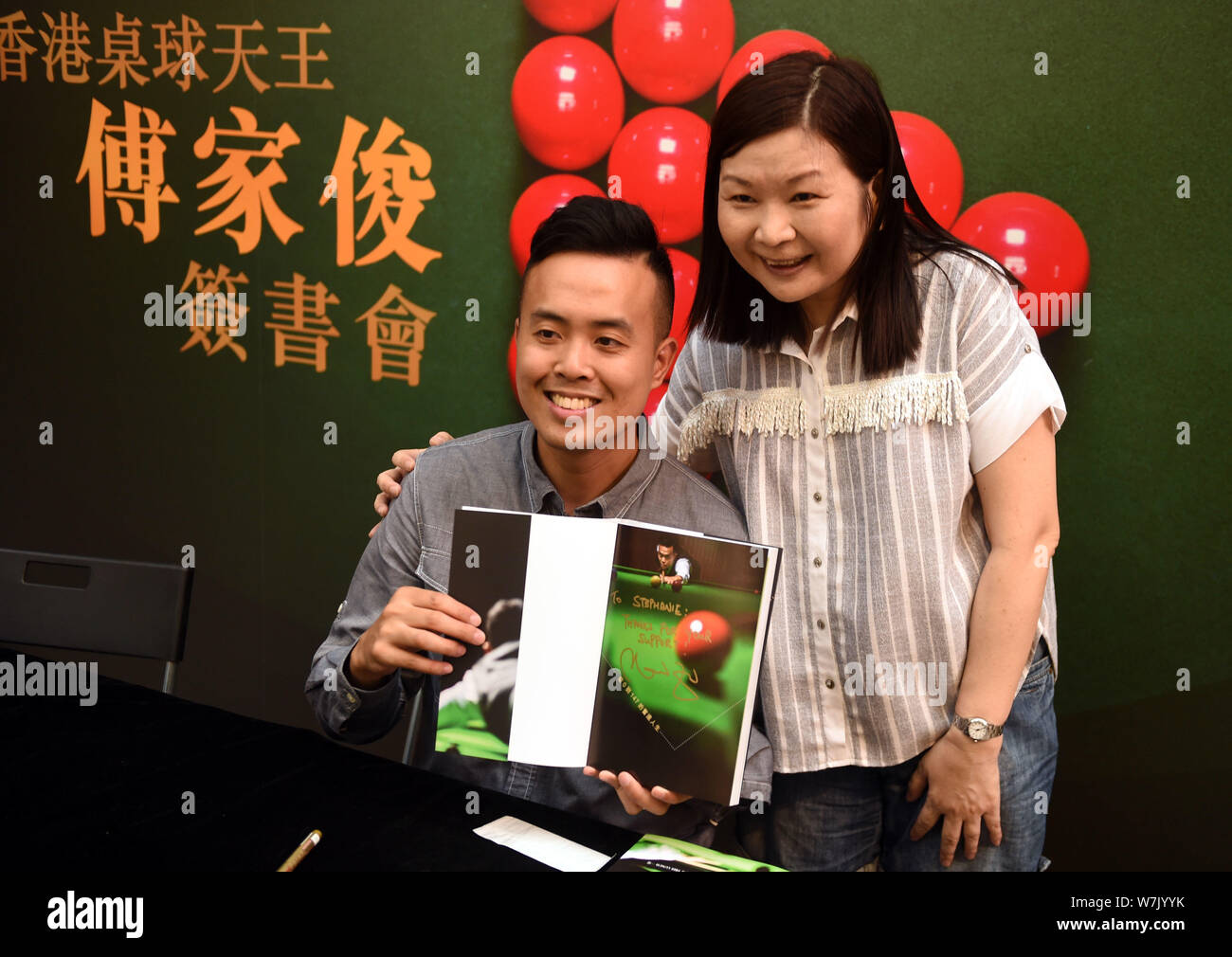 Hong Kong snooker player Marco Fu, left, poses with a fan during a ...