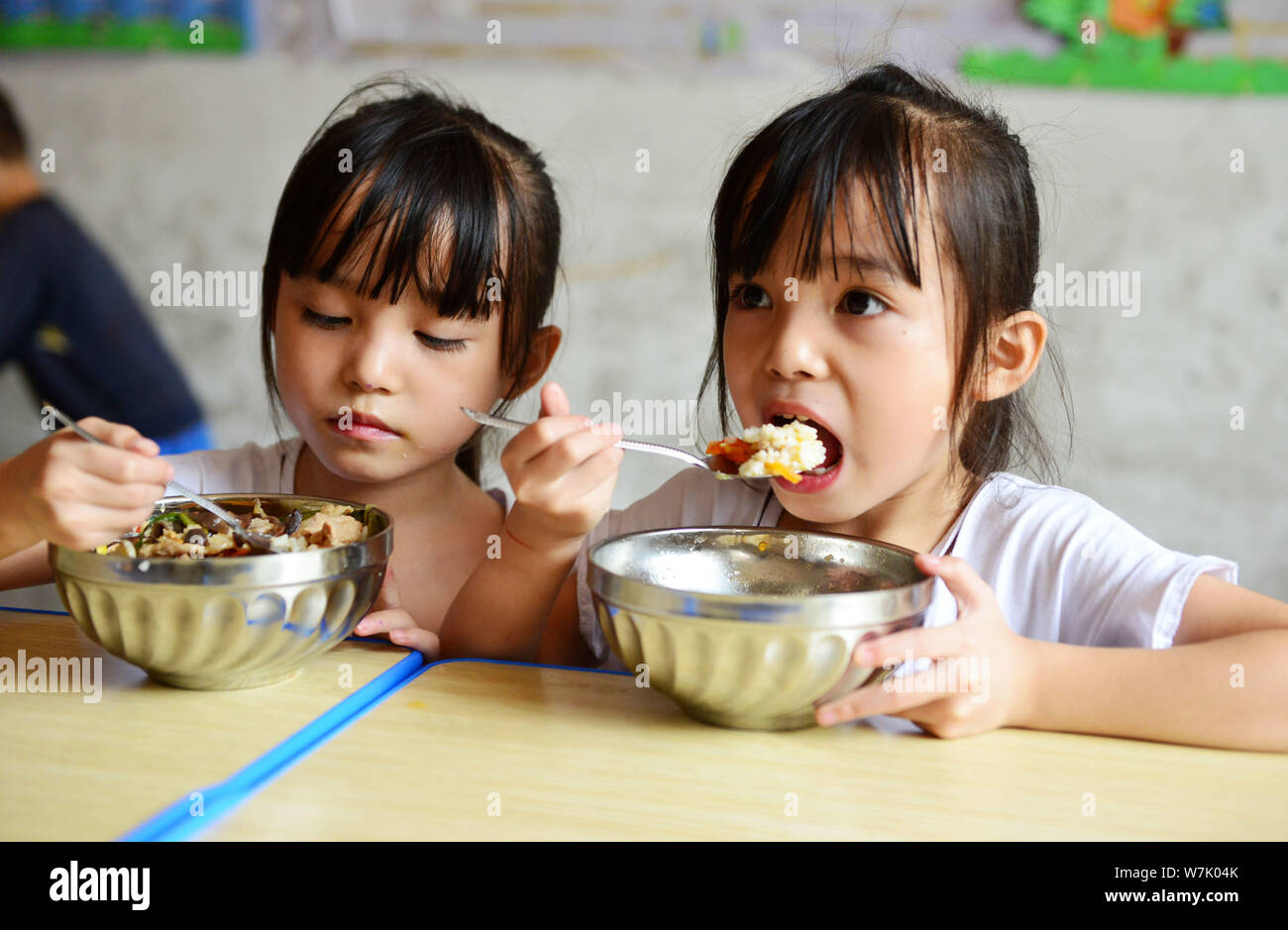Chinese twin girls Liu Yuting, right, and Liu Yuyao take free lunch at ...