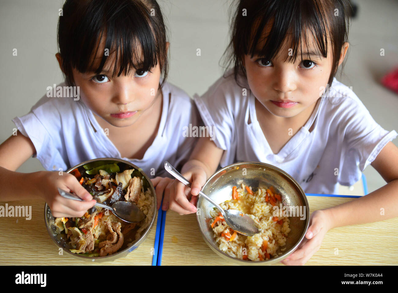 Chinese twin girls Liu Yuting, right, and Liu Yuyao take free lunch at ...
