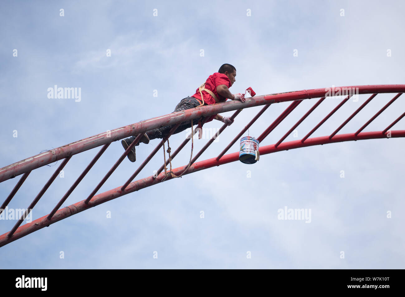 A Chinese worker climbs an arched ladder, which looks like a "ladder to ...