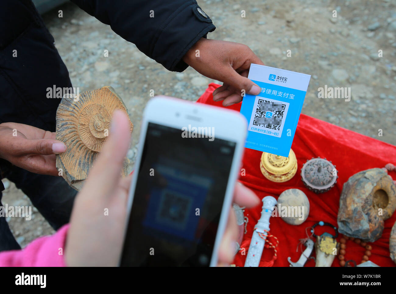 A customer scans a QR code via mobile payment service Alipay of Alibaba ...
