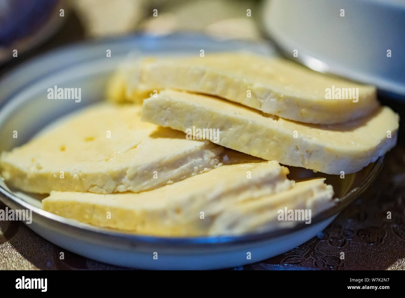 Homemade cheese Bryndza cut in slices in bowl close Stock Photo - Alamy