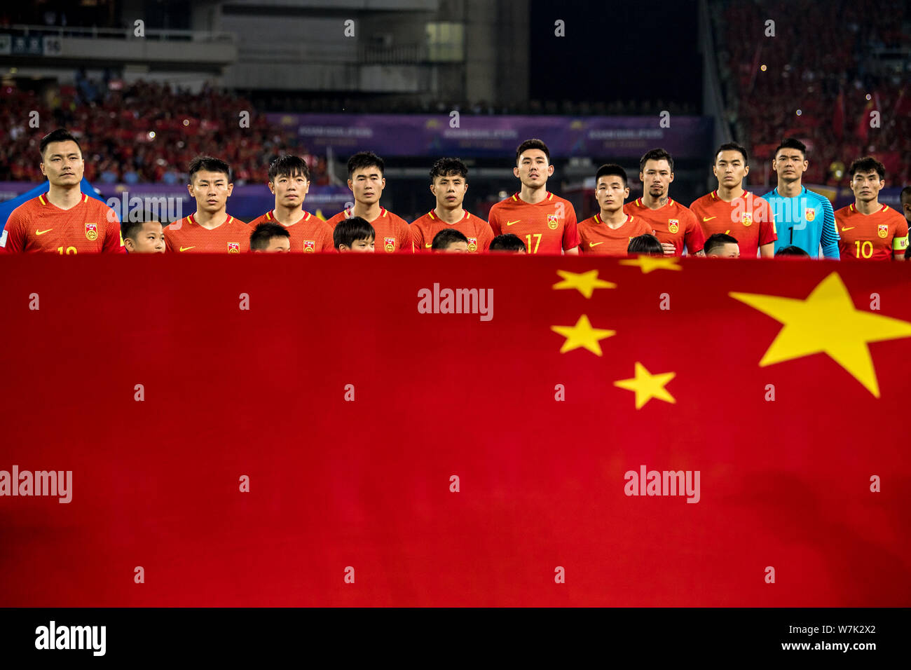 Players of the starting line-up of China pose behind a Chinese national ...
