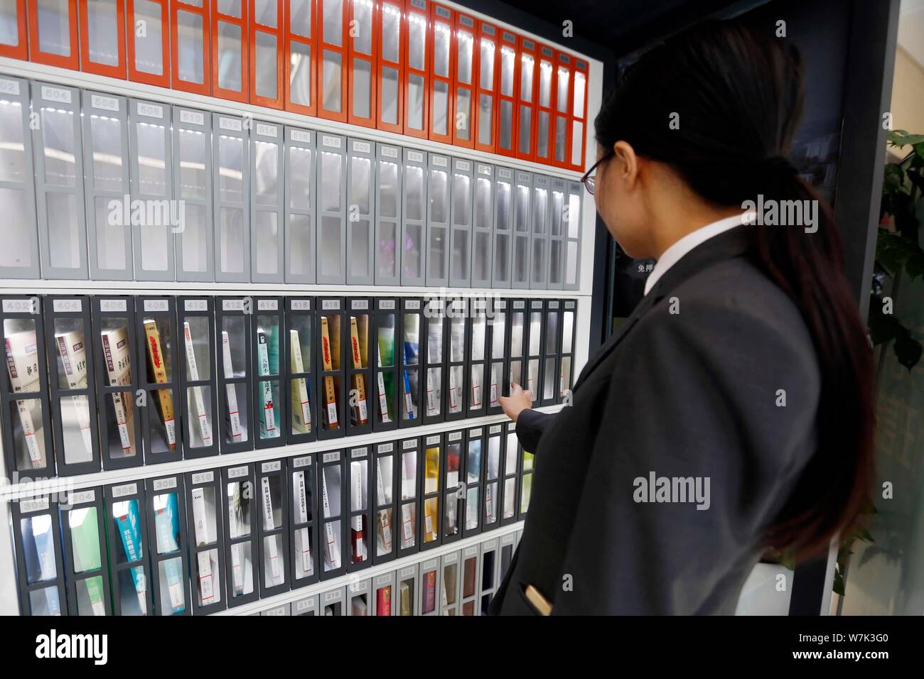 A citizen picks out books for free in front of a shared bookcase ...