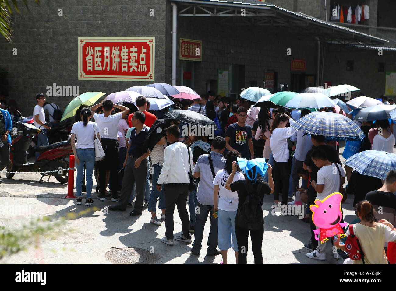 Chinese customers wait in long queue to buy mooncakes in front of a ...