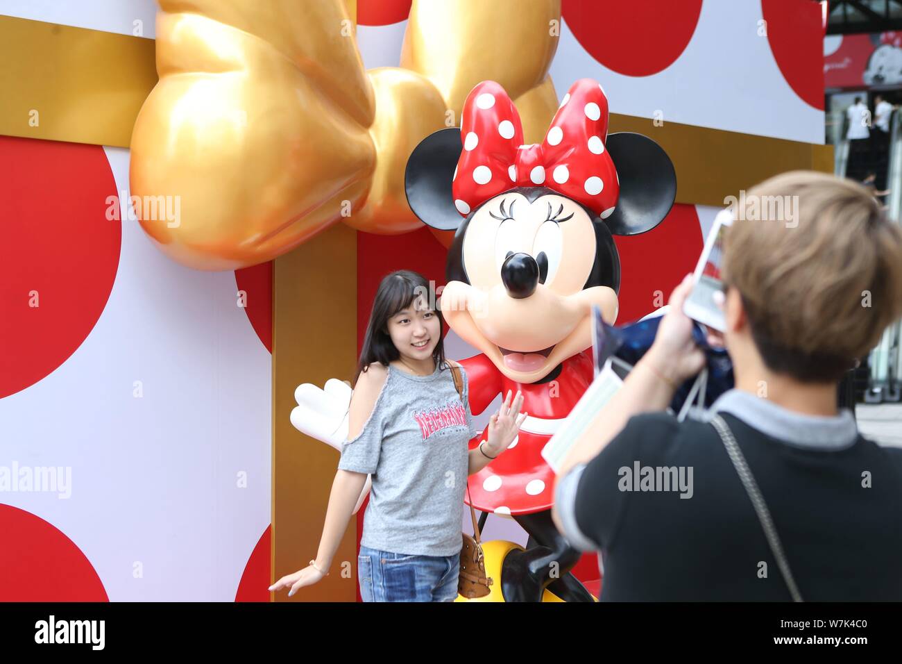 A customer poses for photos with a Minnie Mouse sculpture at the China ...