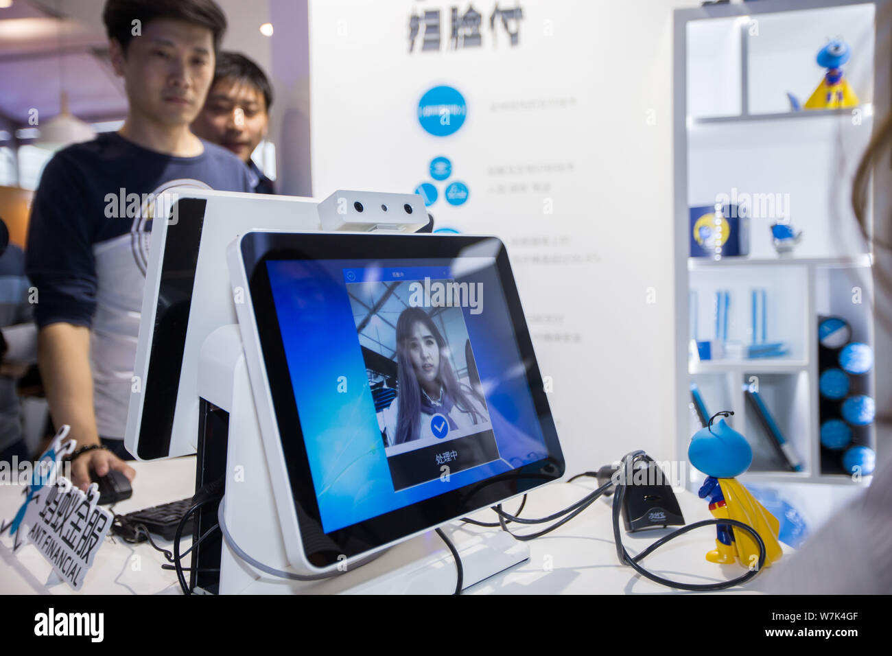 --FILE--One of twin sisters tries out the "Smile to Pay" with face ...