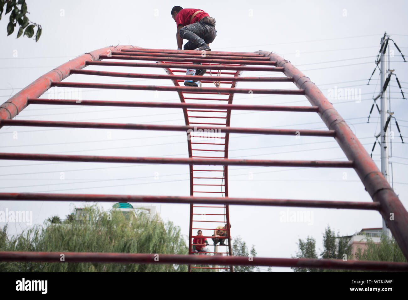 Chinese workers climb an arched ladder, which looks like a "ladder to ...