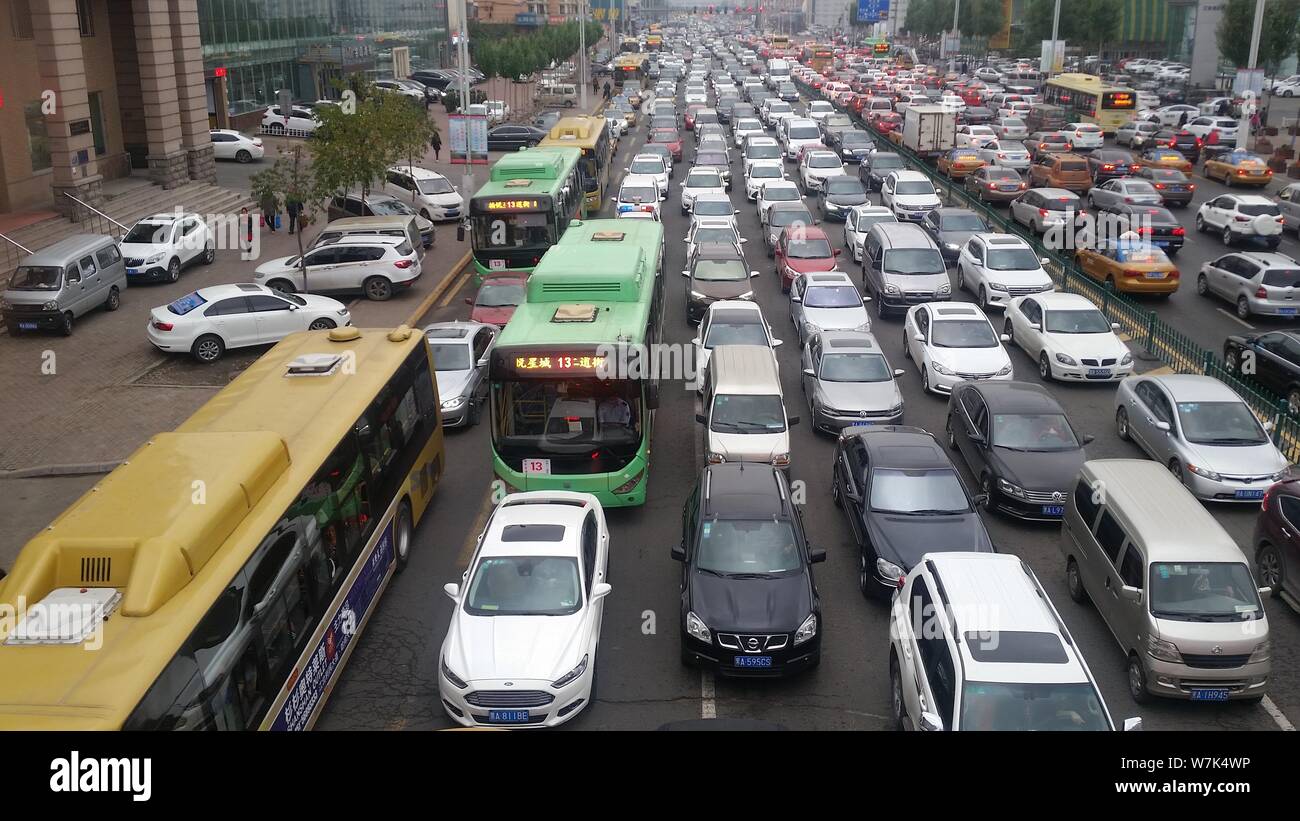 Masses of vehicles move slowly on a road in a traffic jam during rush ...