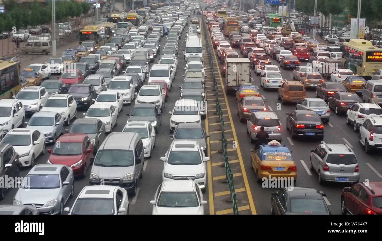 Masses of vehicles move slowly on a road in a traffic jam during rush ...