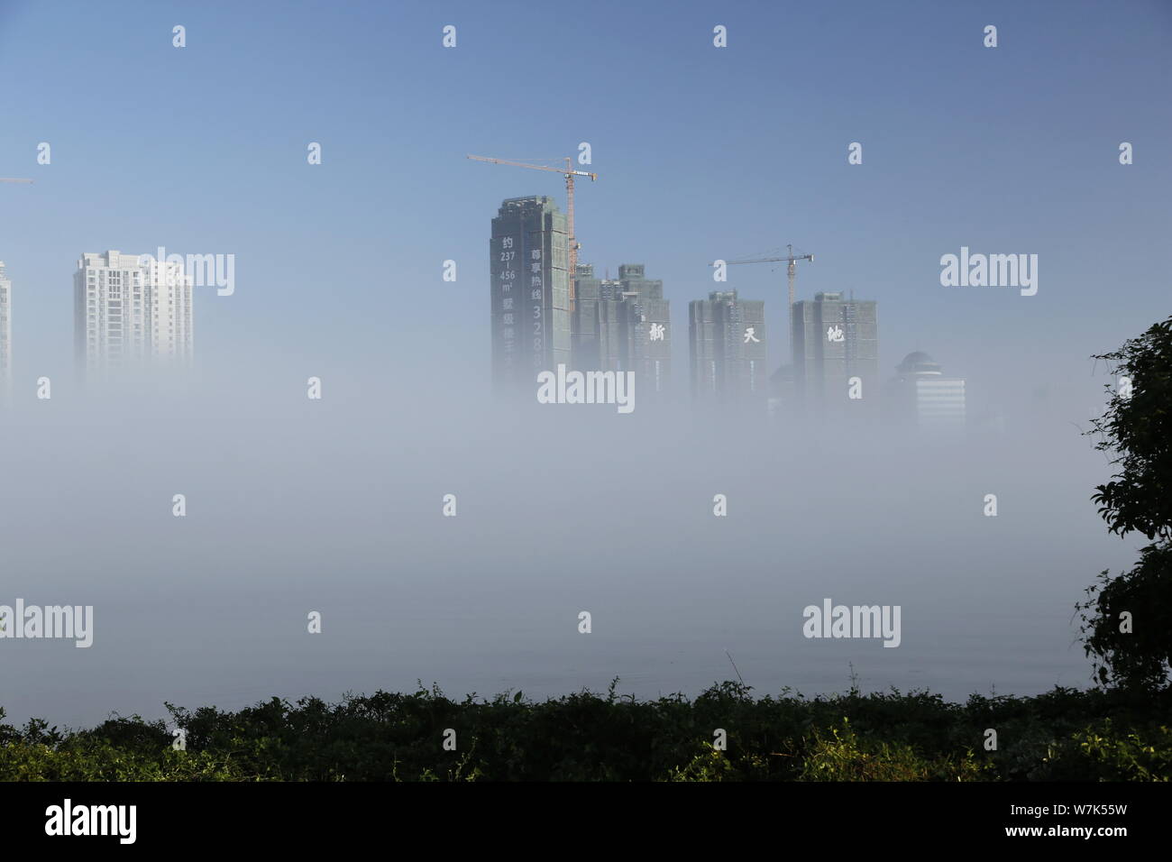 High-rise buildings and skyscrapers are seen vaguely as a mirage ...