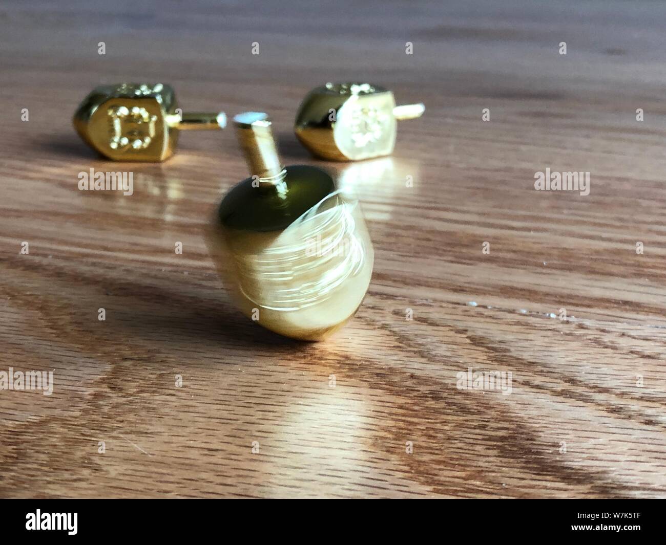 Gold Dreidel spinning top on a wooden floor Hanukkah traditional toy ...